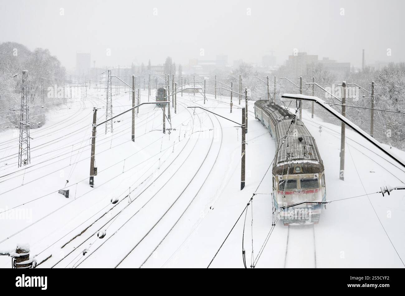 A long train of passenger cars is moving along the railway track ...
