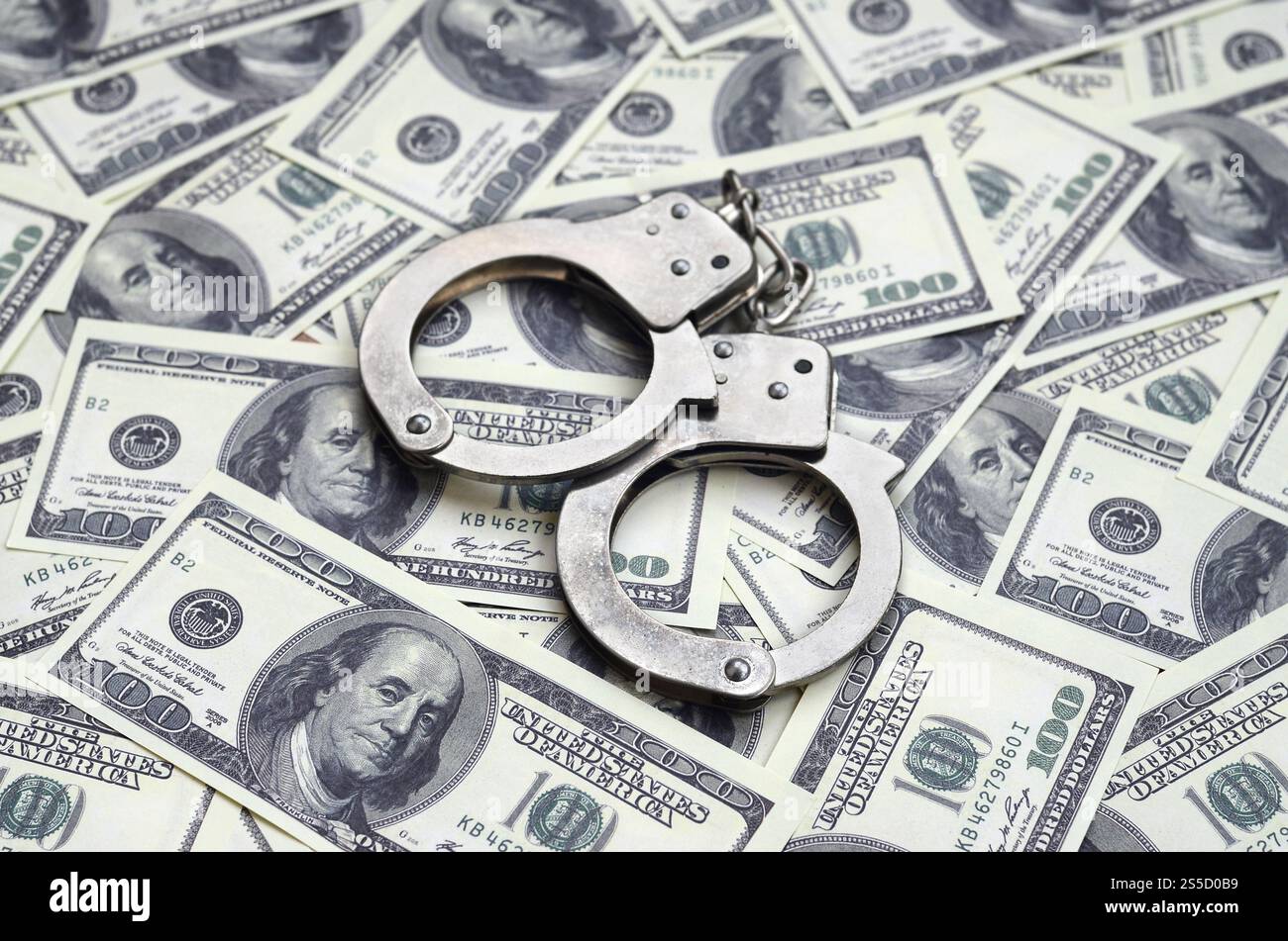 Police handcuffs lie on a lot of dollar bills. The concept of illegal ...