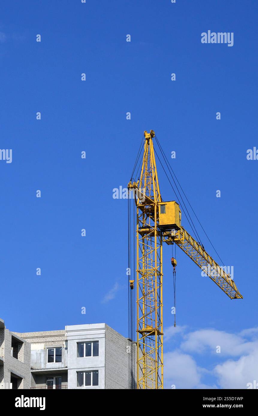 Tall and heavy construction crane towers against a blue sky Stock Photo ...