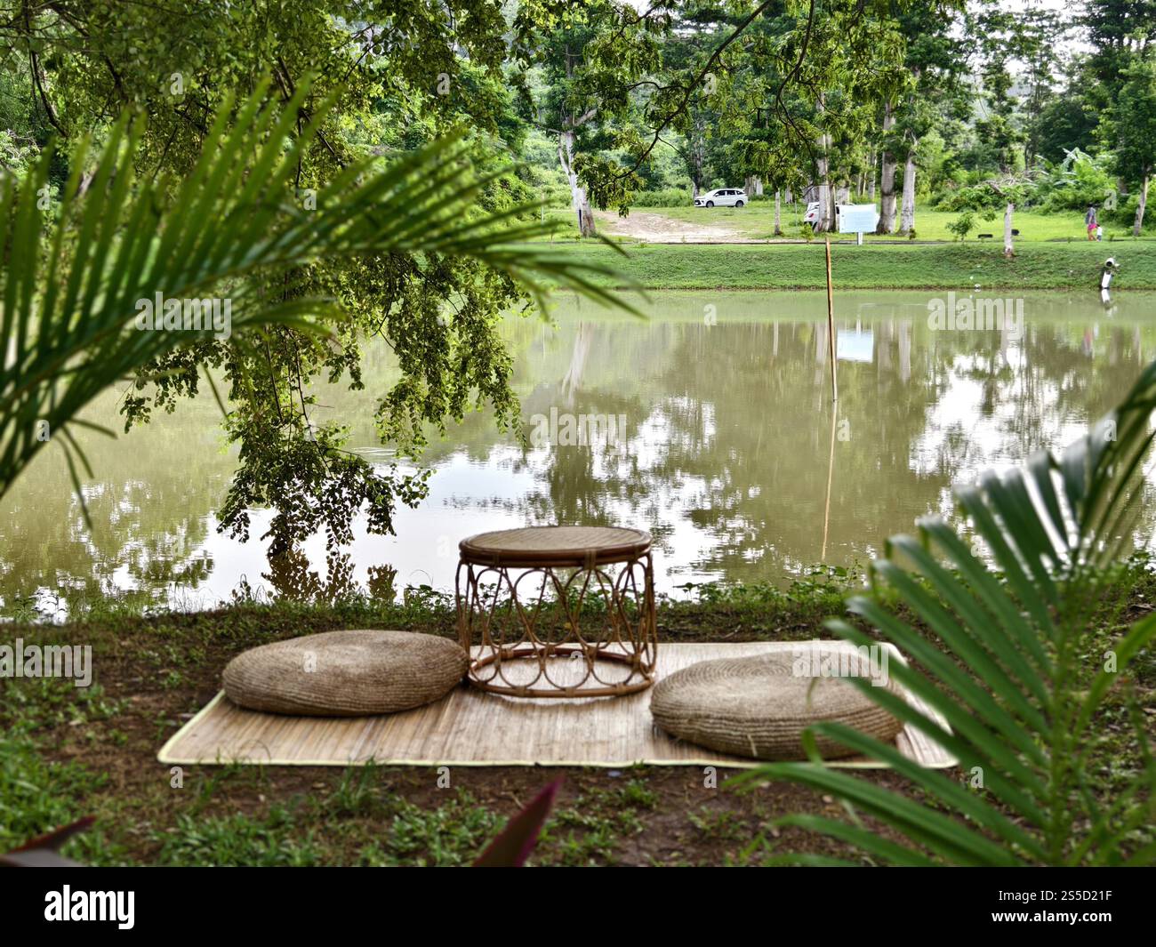 A cozy outdoor seating featuring a woven table and cushions on a mat ...