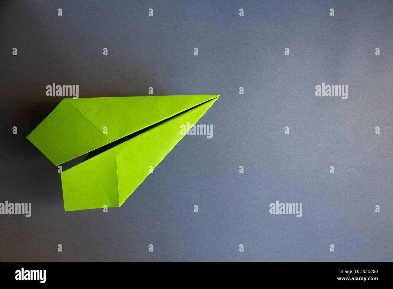 Green paper plane origami isolated on a blank grey background. Green ...