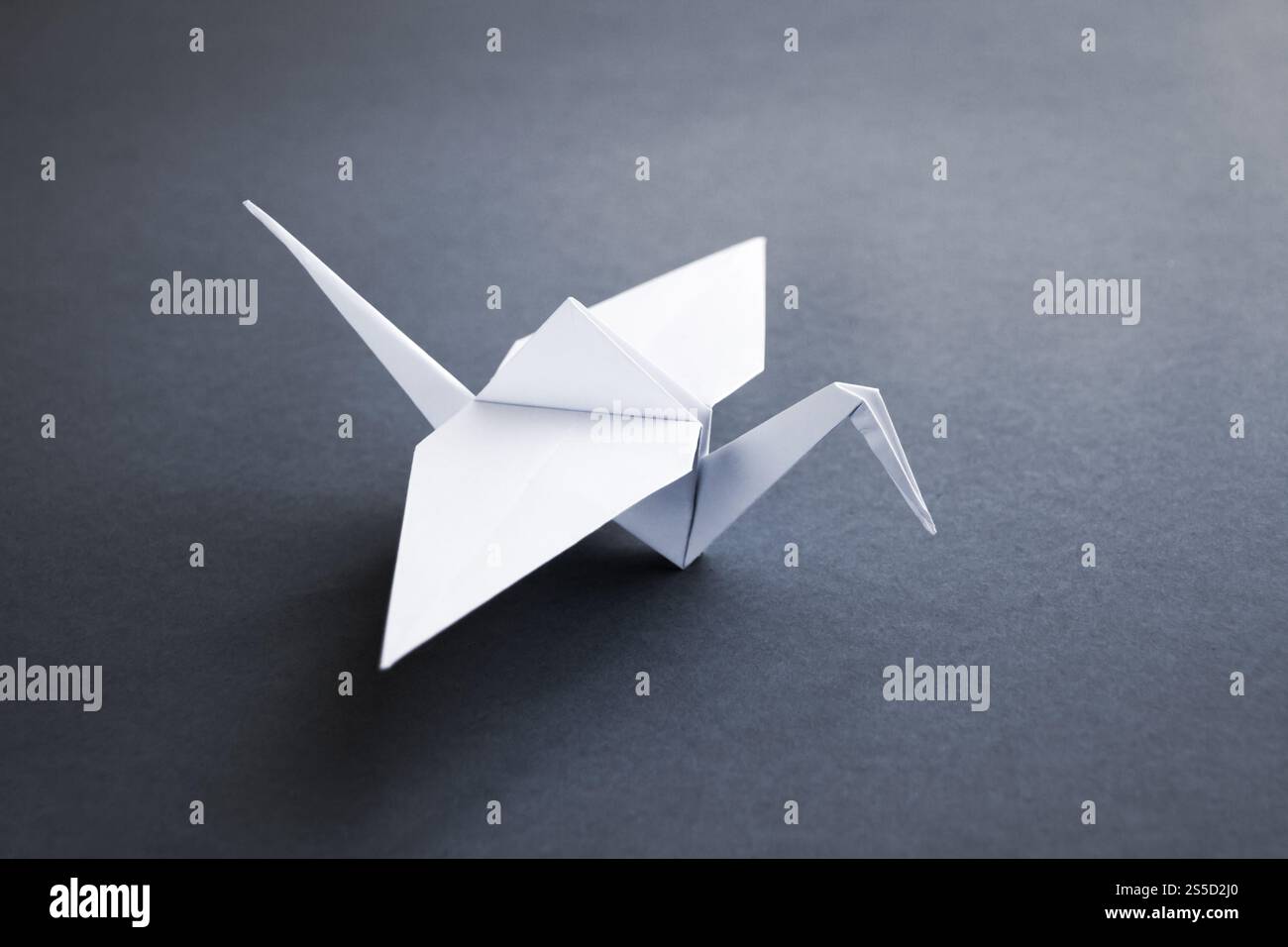 White paper crane origami isolated on a blank grey background. White ...