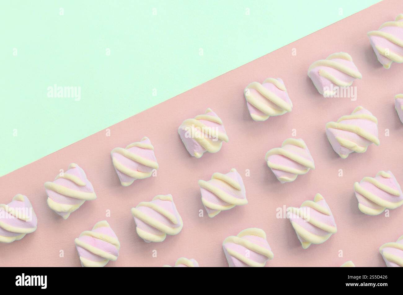 Colorful marshmallow laid out on turquoise and pink paper background ...