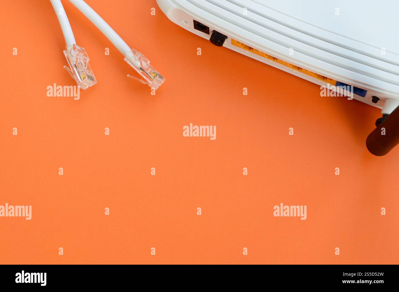 Internet router and Internet cable plugs lie on a bright orange ...