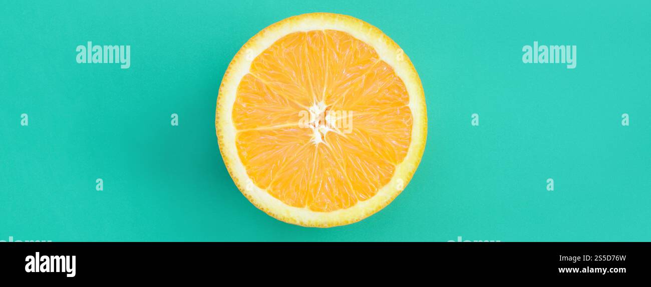 Top view of a one orange fruit slice on bright background in turquoise ...
