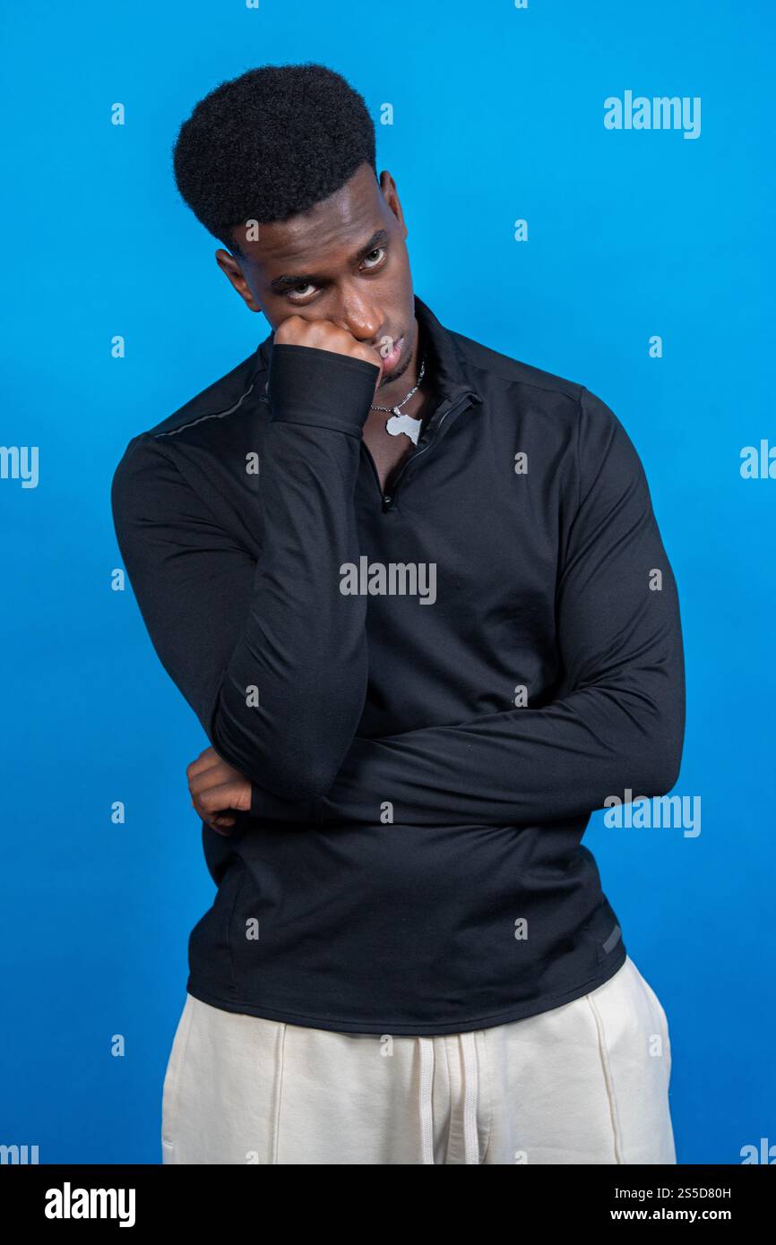 Bored young man with hand on his face showing apathy posing on blue ...