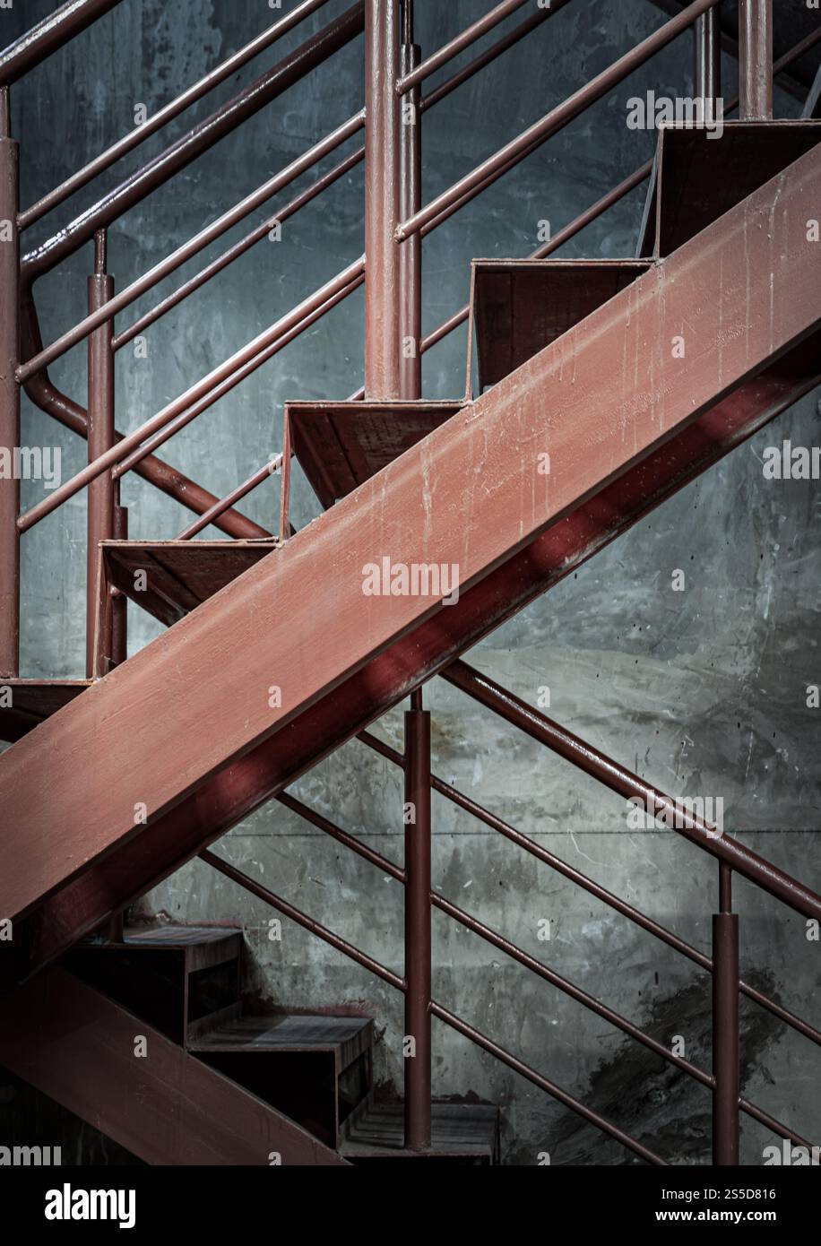 Vertical view of Old Steel ladder with handrails with concrete wall in ...