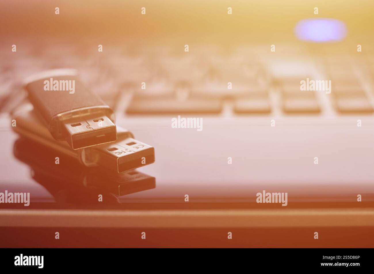 USB flash cards lying on black laptop case in front of his keyboard ...