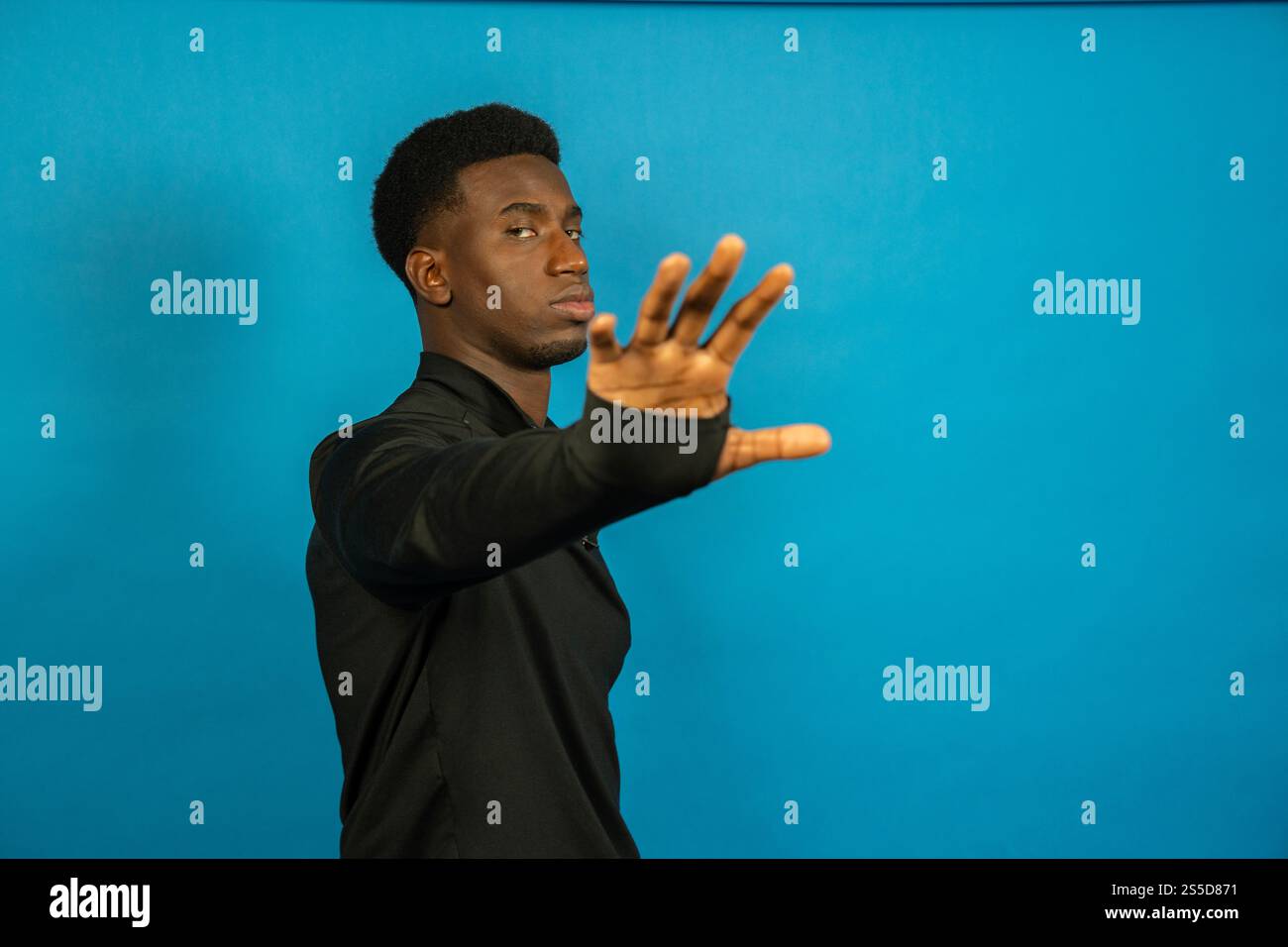 Young man showing stop sign with hand gesture, expressing refusal or ...