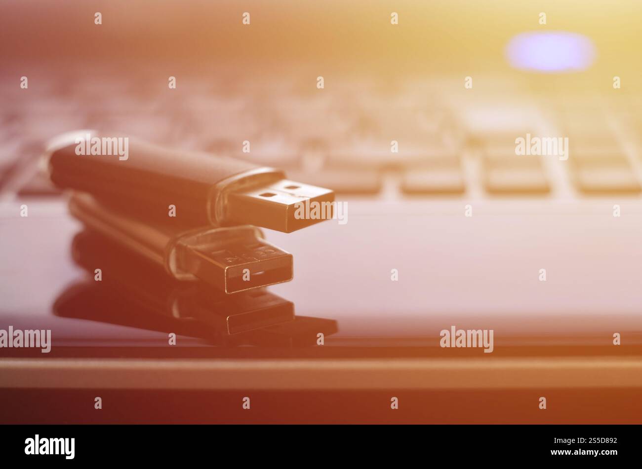 USB flash cards lying on black laptop case in front of his keyboard ...