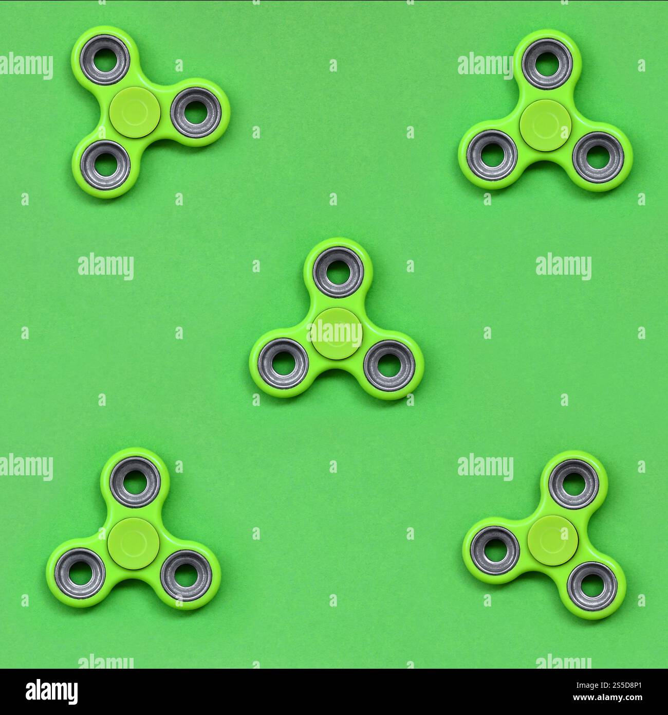 Many green fidget spinners lies on texture background of fashion pastel ...