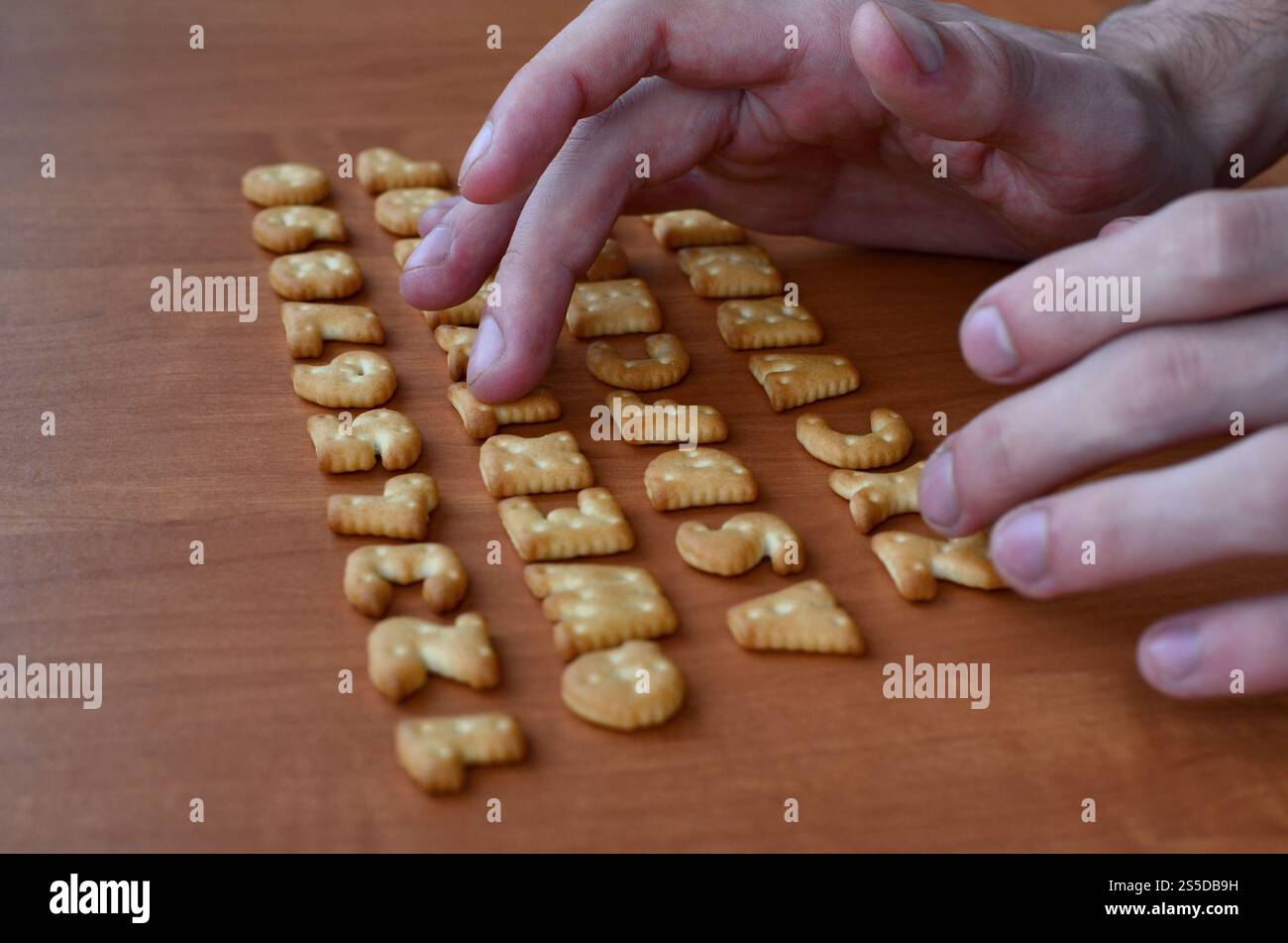 Mens fingers typing on the keyboard, which is composed of salty cracker ...