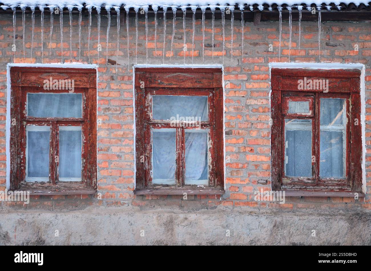 The texture of a brick wall with a few windows. Glazed windows in the ...