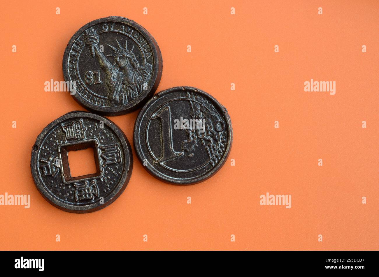 Three chocolate products in the form of Euro, USA and Japan coins lie ...