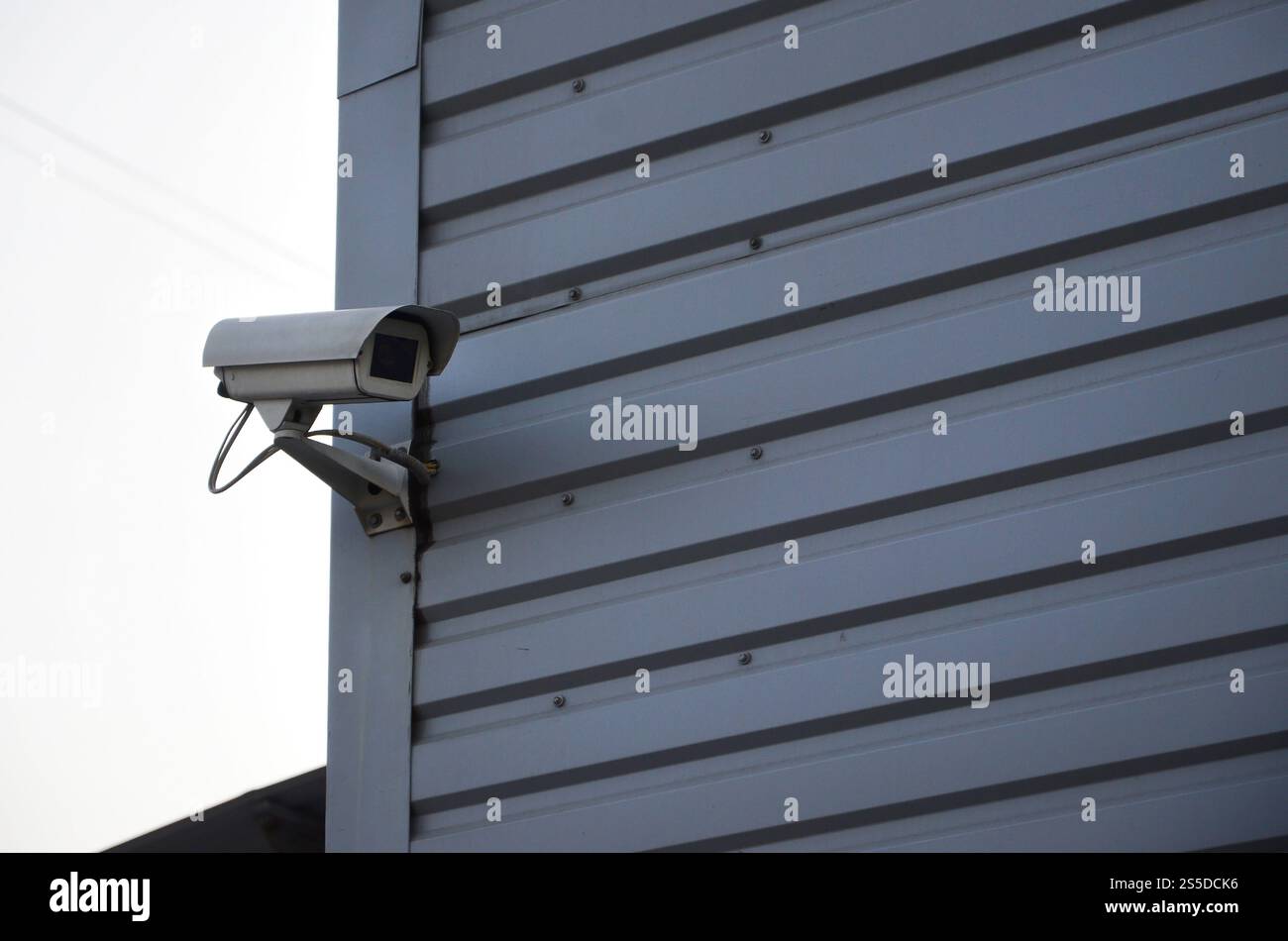 White surveillance camera built into the metal wall of the office ...
