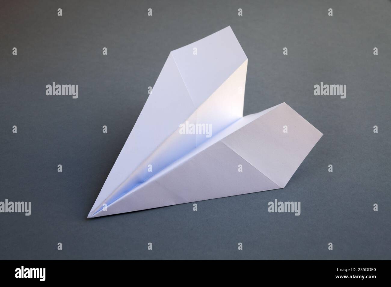White paper plane origami isolated on a blank grey background. White ...