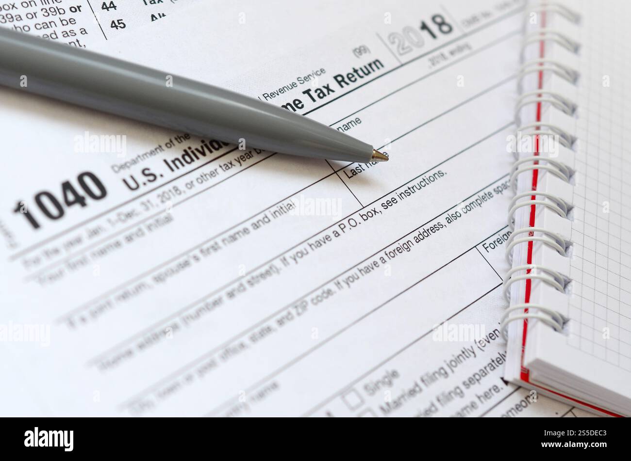 The pen and notebook is lies on the tax form 1040 U.S. Individual ...