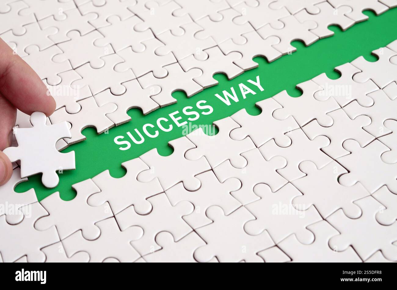 The human hand paves the way to the surface of the jigsaw puzzle ...