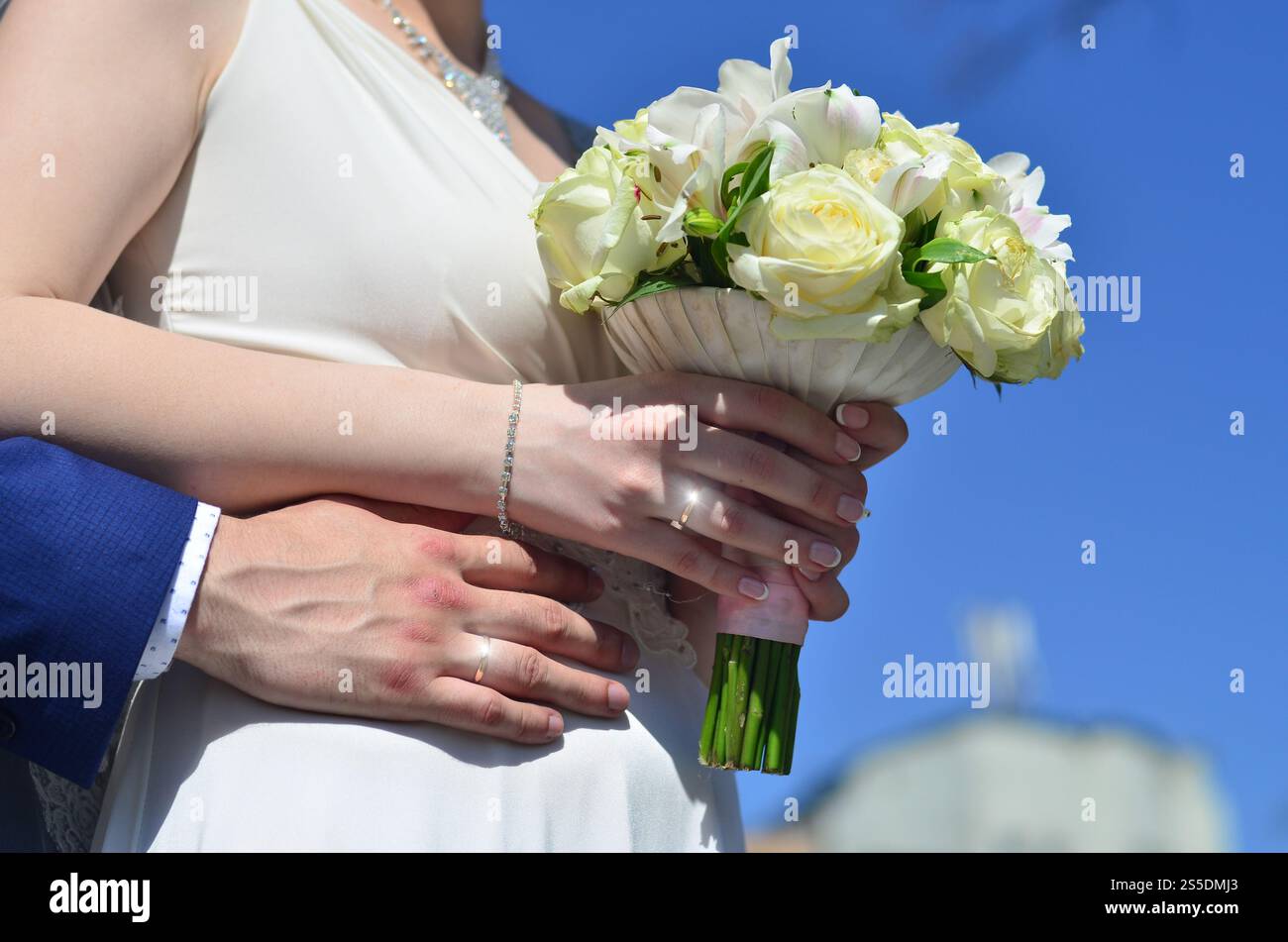 The newlywed couple is holding a beautiful wedding bouquet. Classical ...