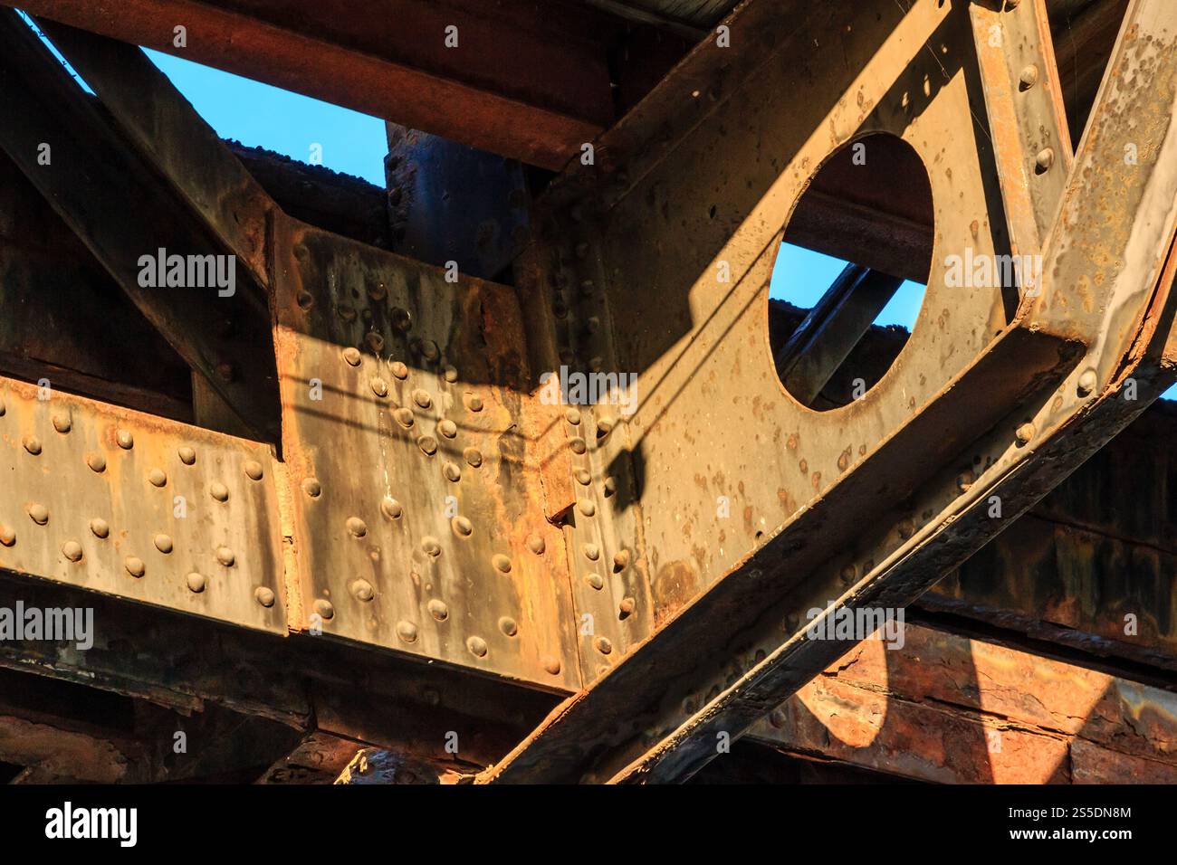A rusted metal beam with a hole in the middle. The beam is old and has ...