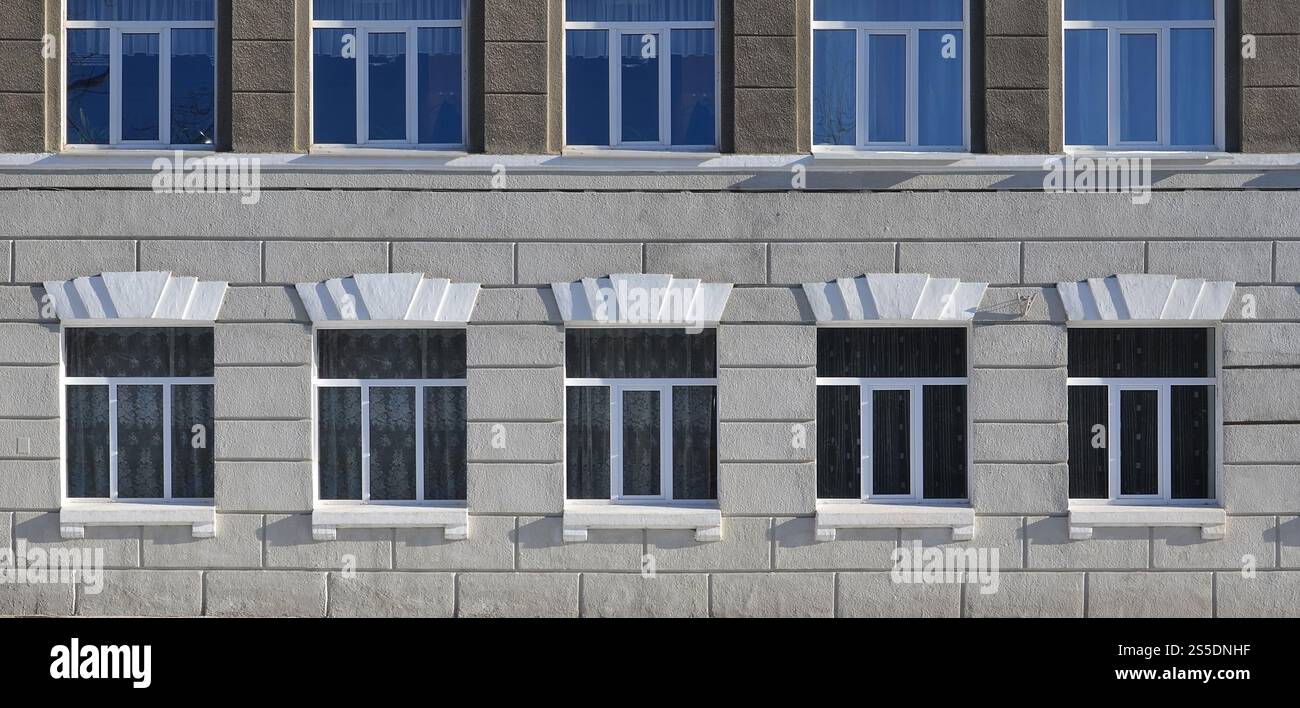 Texture of a glazed modern windows of a grey concrete building. Close ...