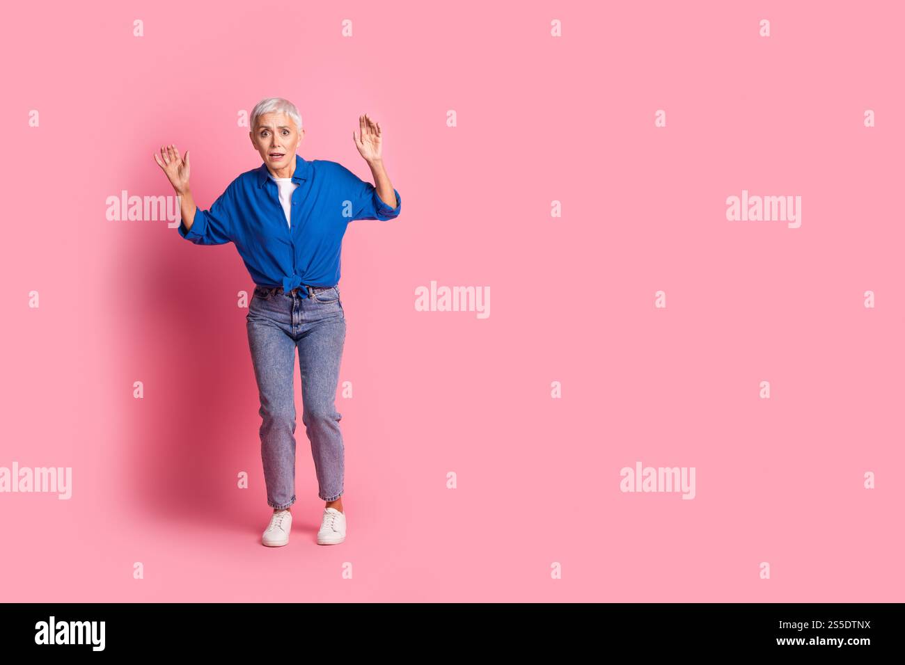 Full length photo of shocked scared woman wear blue shirt rising arms ...