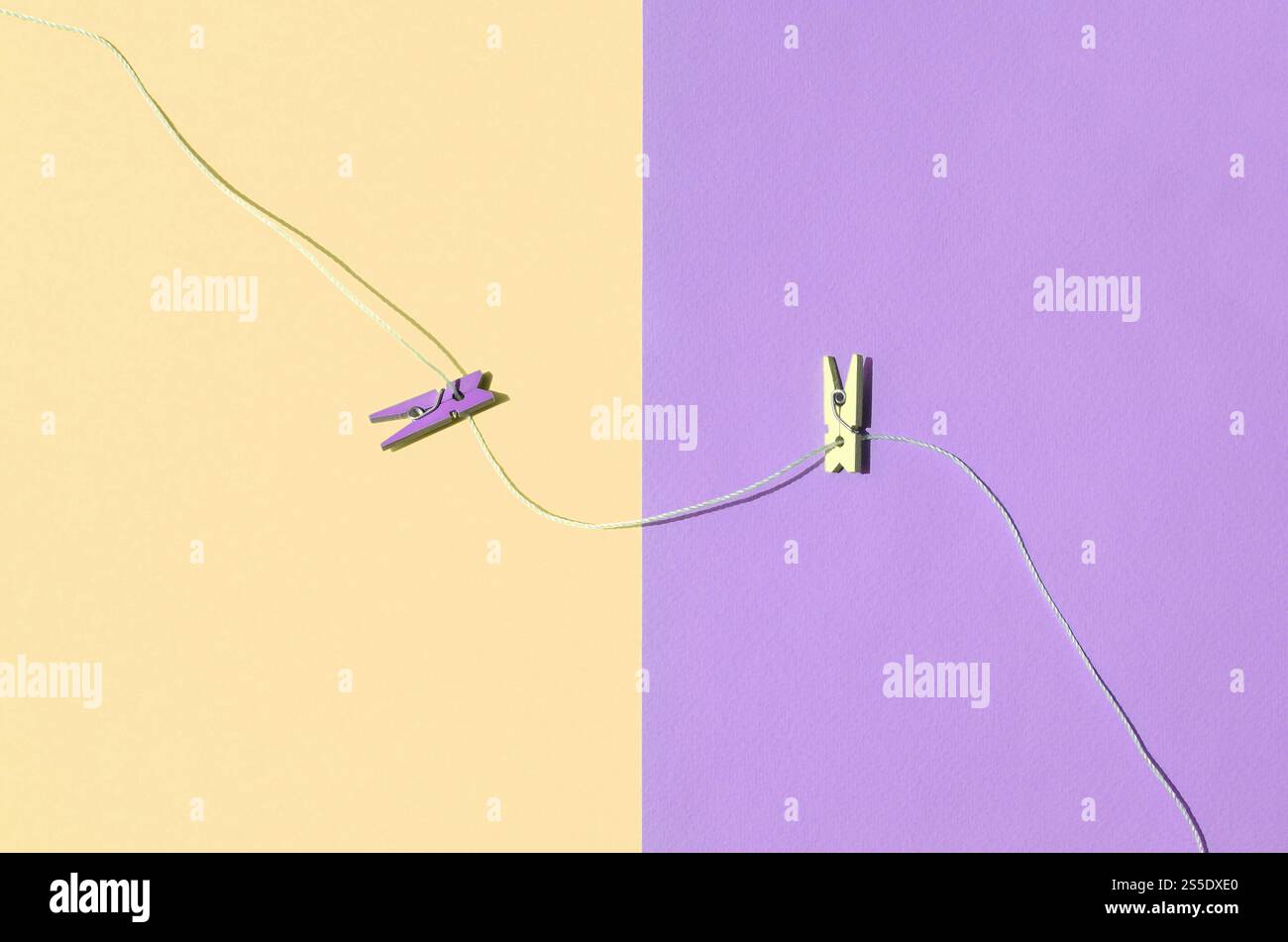 Two colored wooden pegs and small rope lie on texture background of ...