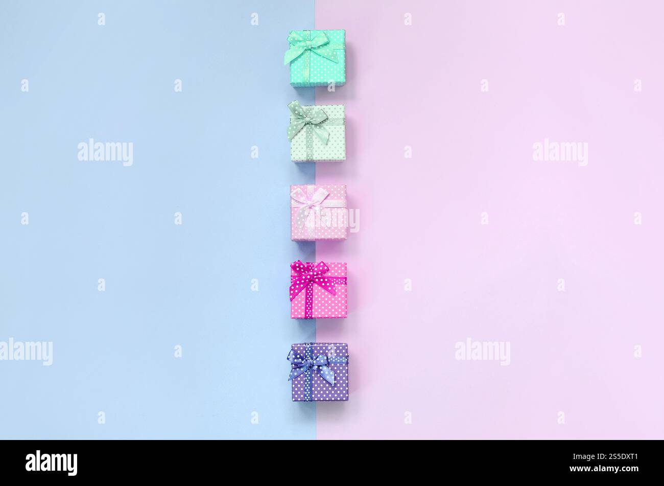 Small gift boxes of different colors with ribbons lies on a violet and ...