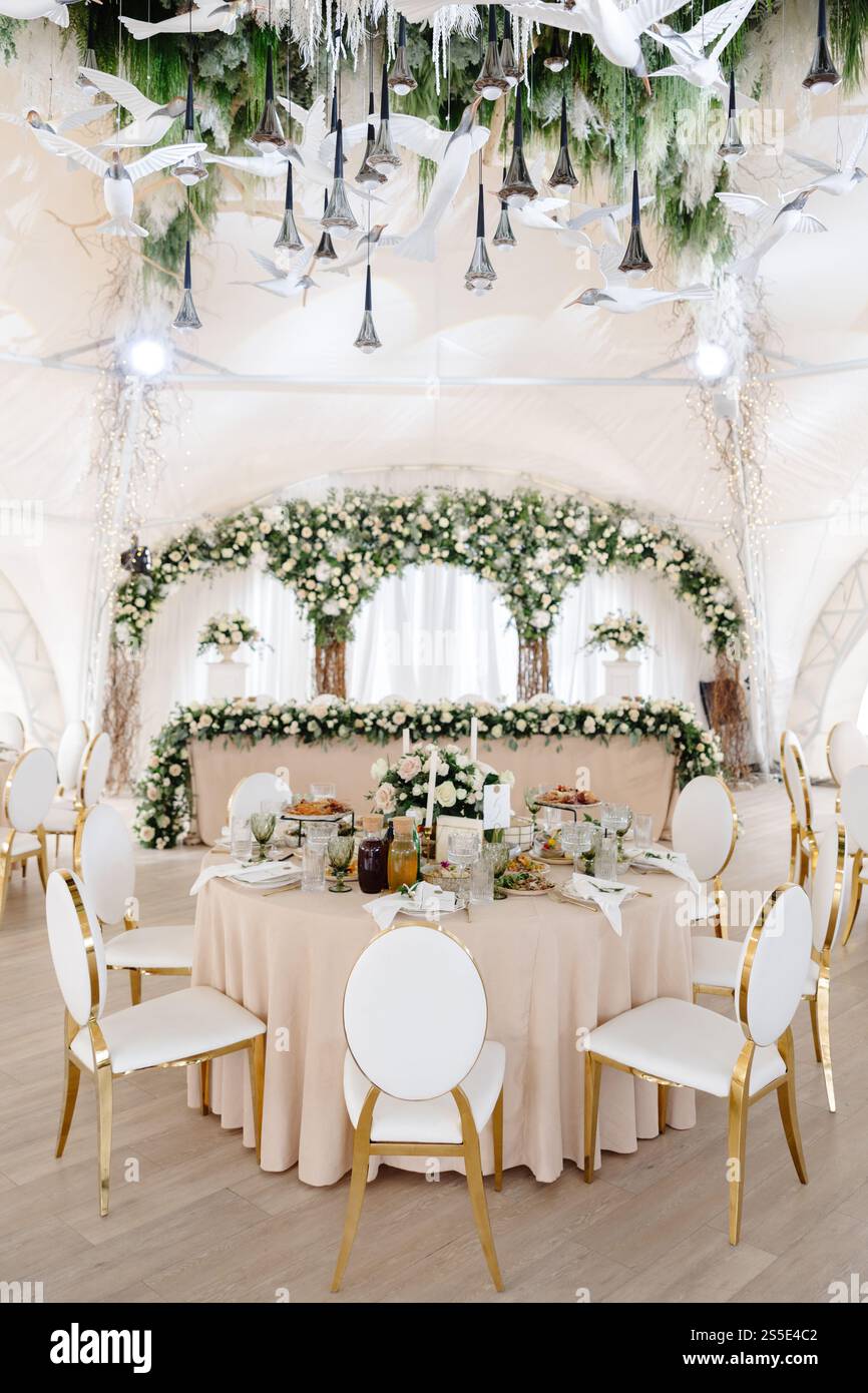Luxurious wedding setup with round tables, stylish chairs, and ...