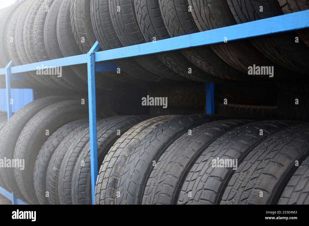 Rack with variety of car tires in automobile store. Many black tires ...