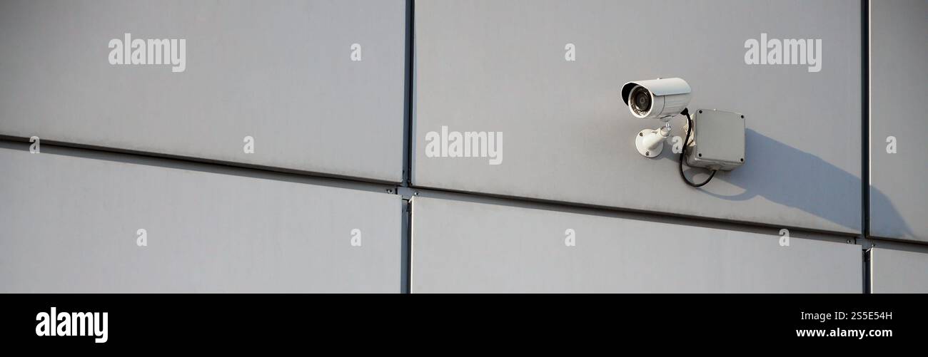 White surveillance camera built into the metal wall of the office ...