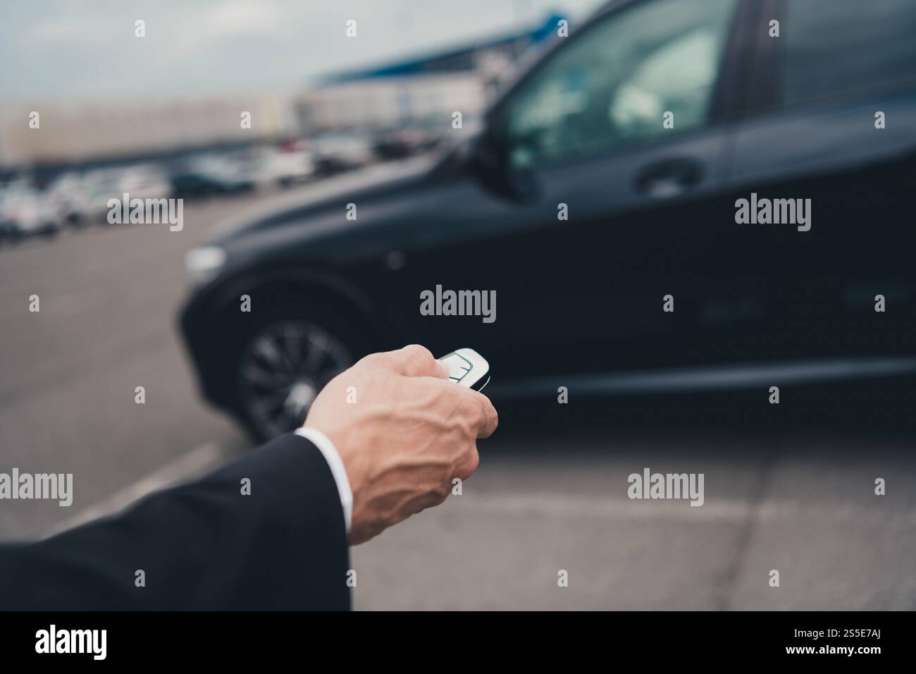 Mature businessman holding car key fob near automobile in city parking ...