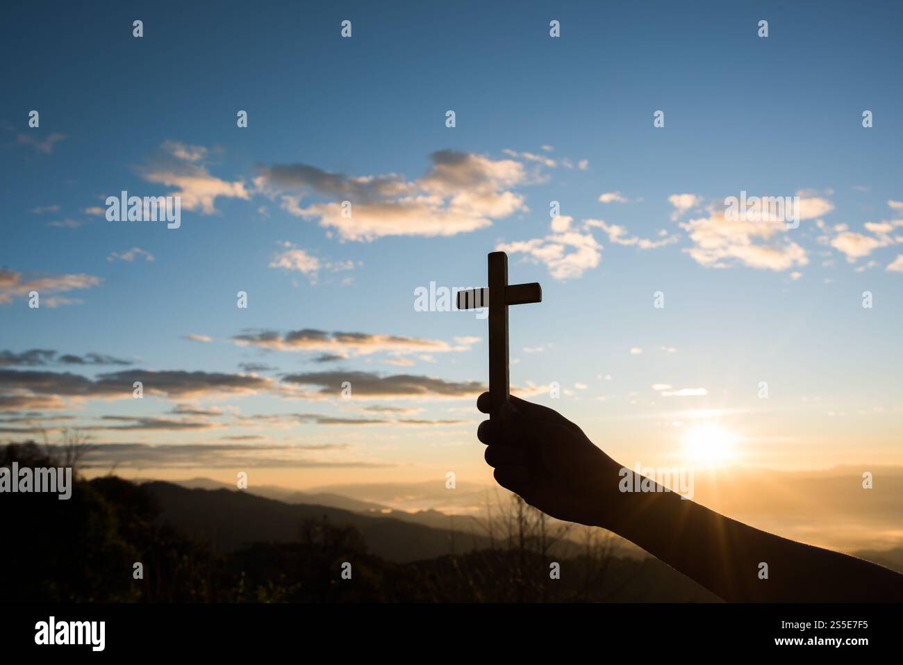 Silhouette of Hand hold cross of God Stock Photo - Alamy