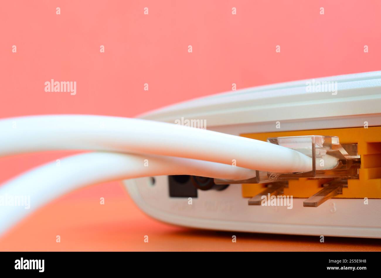 The Internet Cable Plugs Are Connected To The Internet Router Which Lies On A Bright Orange