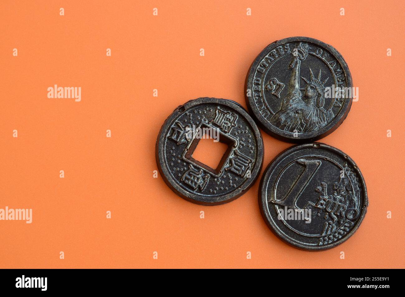 Three chocolate products in the form of Euro, USA and Japan coins lie ...