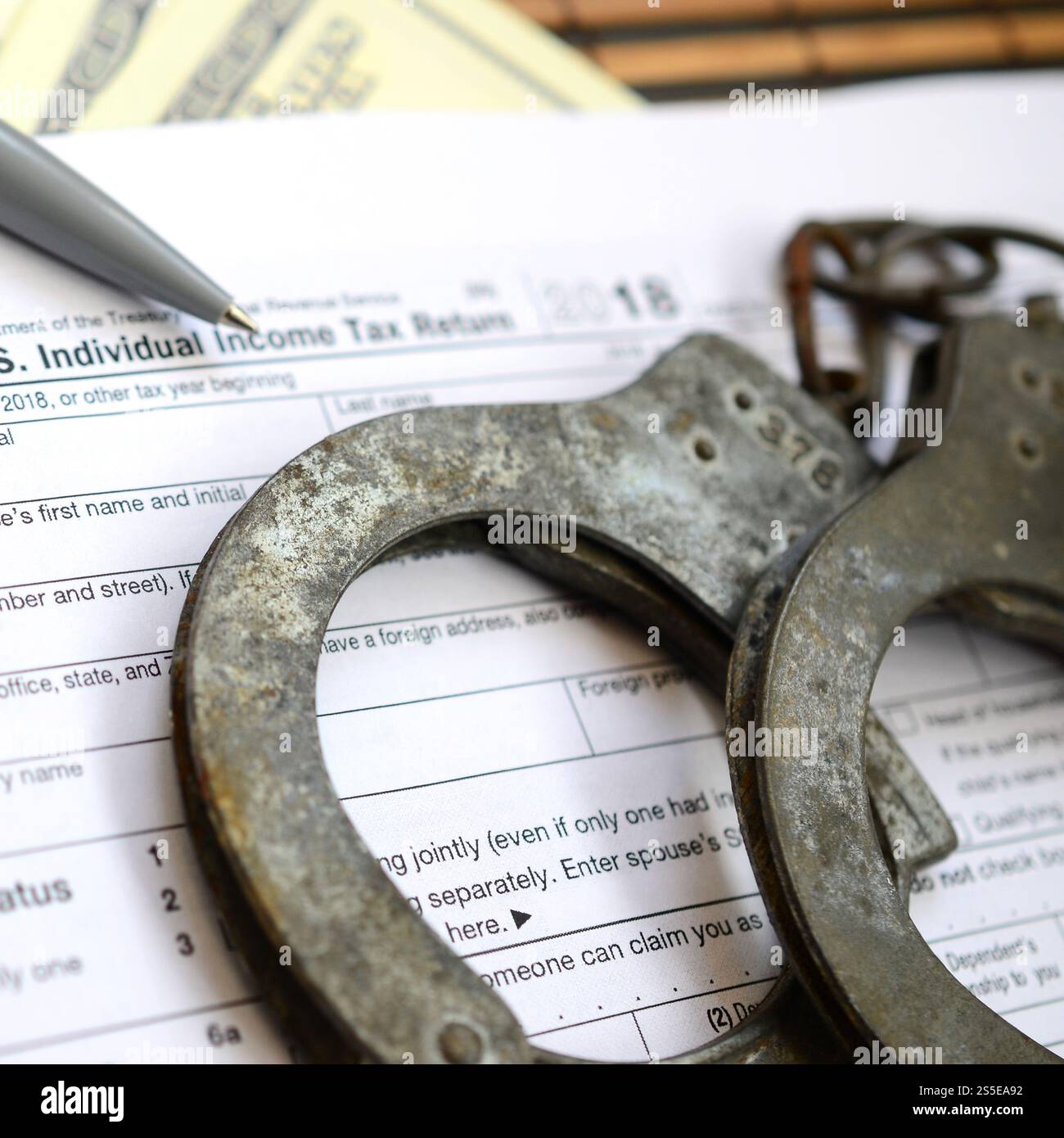 Police handcuffs lie on the tax form 1040. The concept of problems with ...