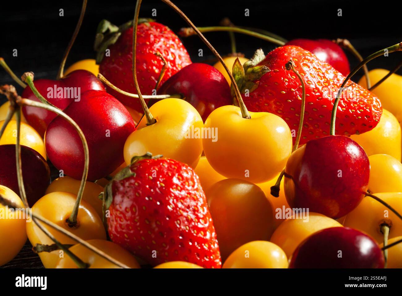 mixed cherries strawberry on black background Stock Photo - Alamy