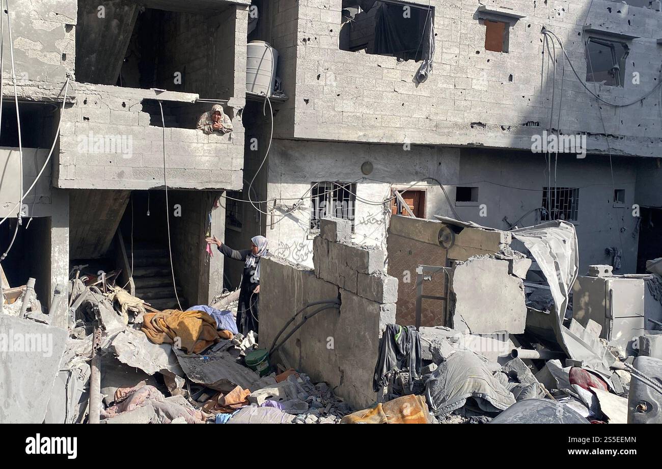 Residents inspect buildings damaged in the Israeli attack, in Gaza City ...