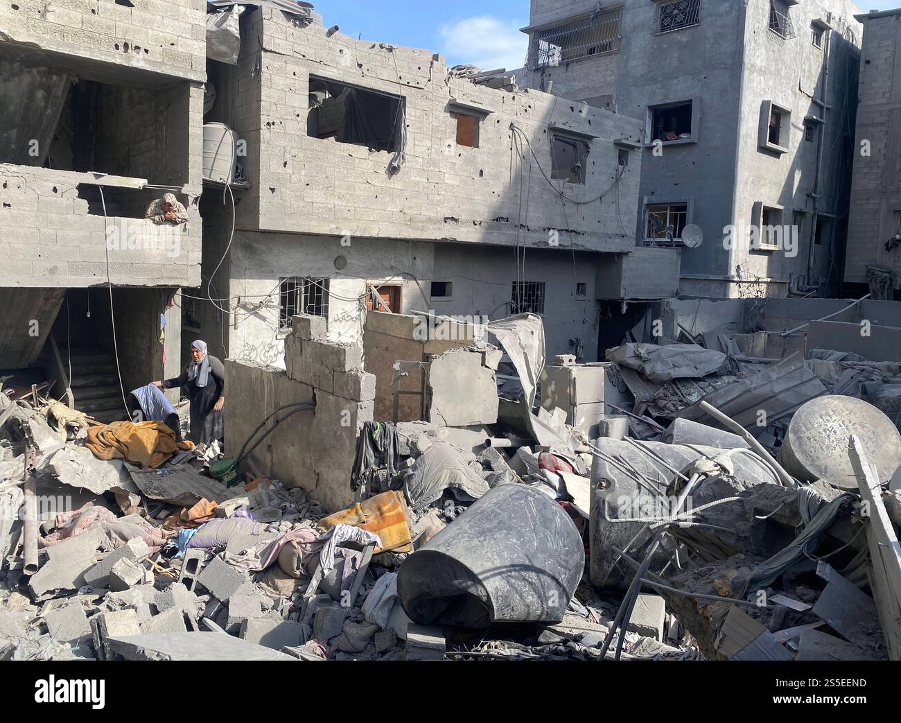 Residents inspect buildings damaged in the Israeli attack, in Gaza City ...