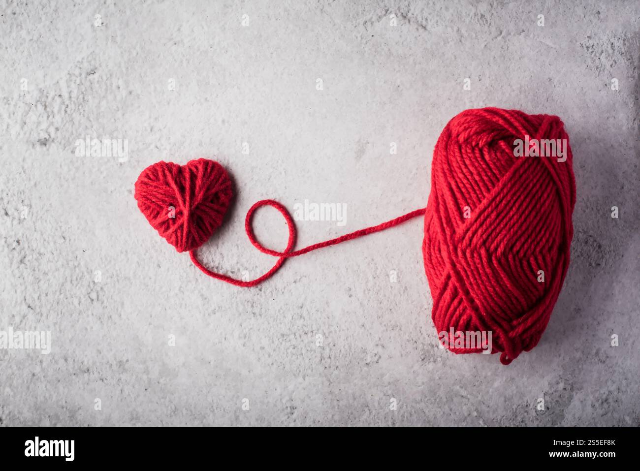 Red yarn heart shaped on the wall background Stock Photo - Alamy