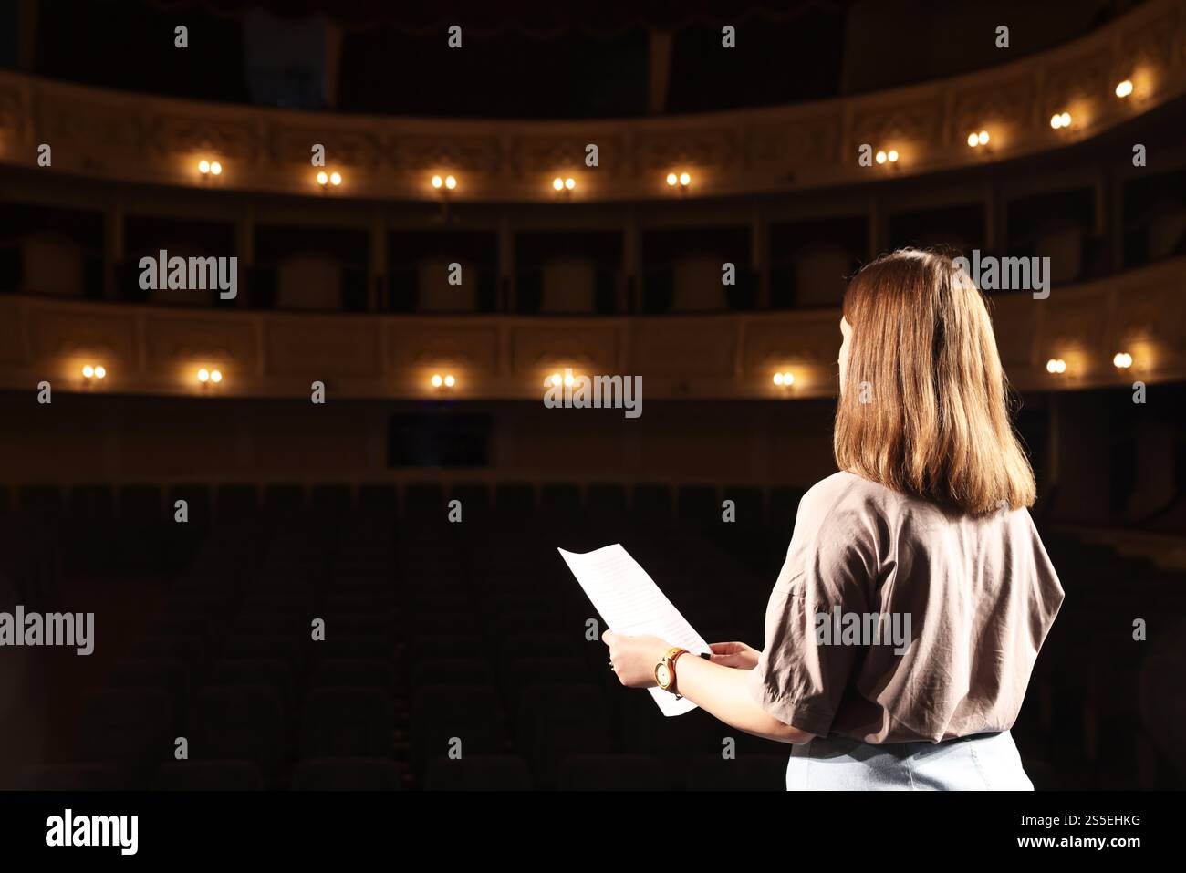 Professional actress rehearsing on stage in theatre, back view Stock ...