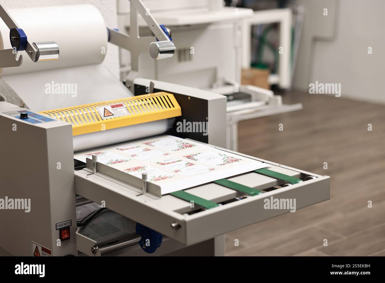 Modern roll laminator and paper sheet with invitation cards indoors ...