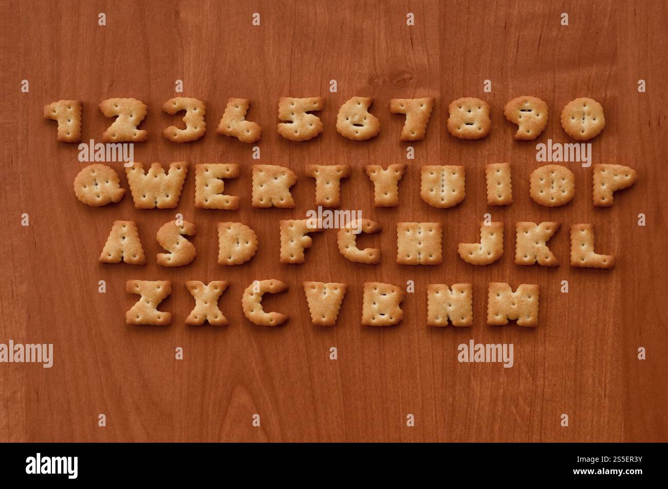Letters of salty crackers lay on a wooden brown surface in the order ...