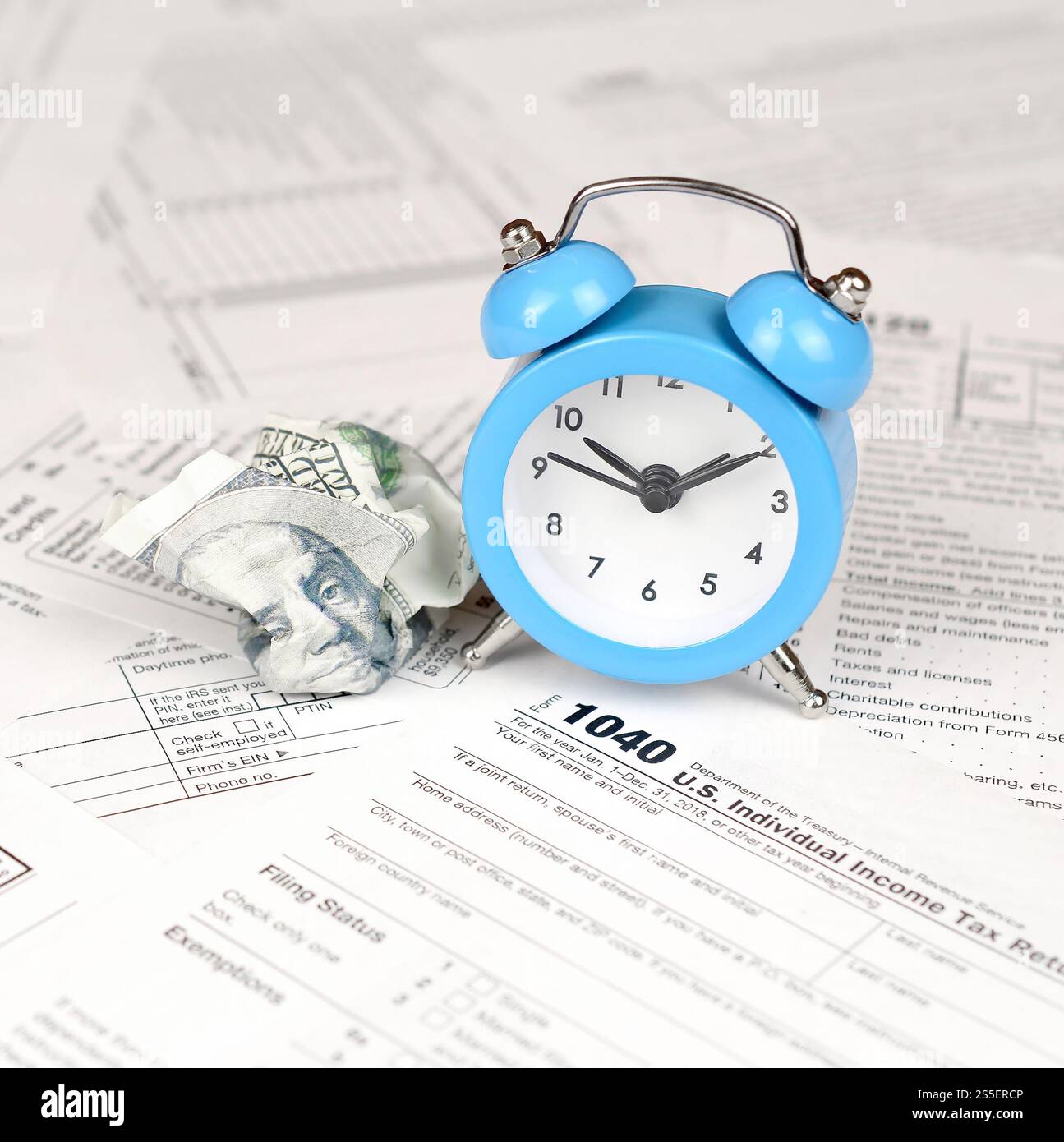 1040 Individual income tax return form with blue alarm clock and ...