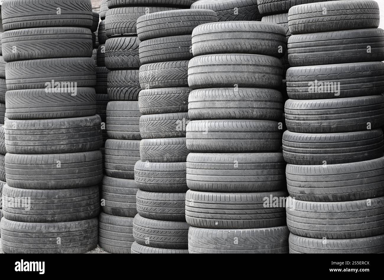 Old used tires stacked with high piles in secondary car parts shop ...