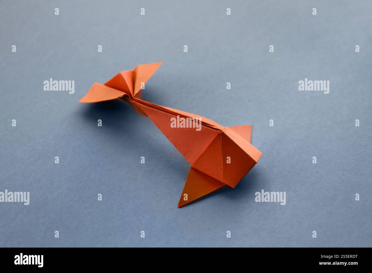 Orange paper fish origami isolated on a blank grey background. Orange ...