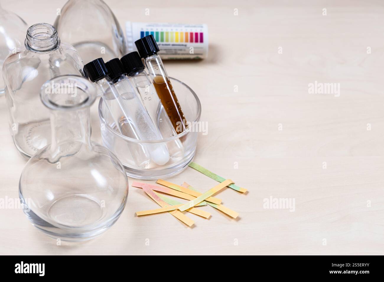 test tubes with various liquids, bottles and used indicators on light ...