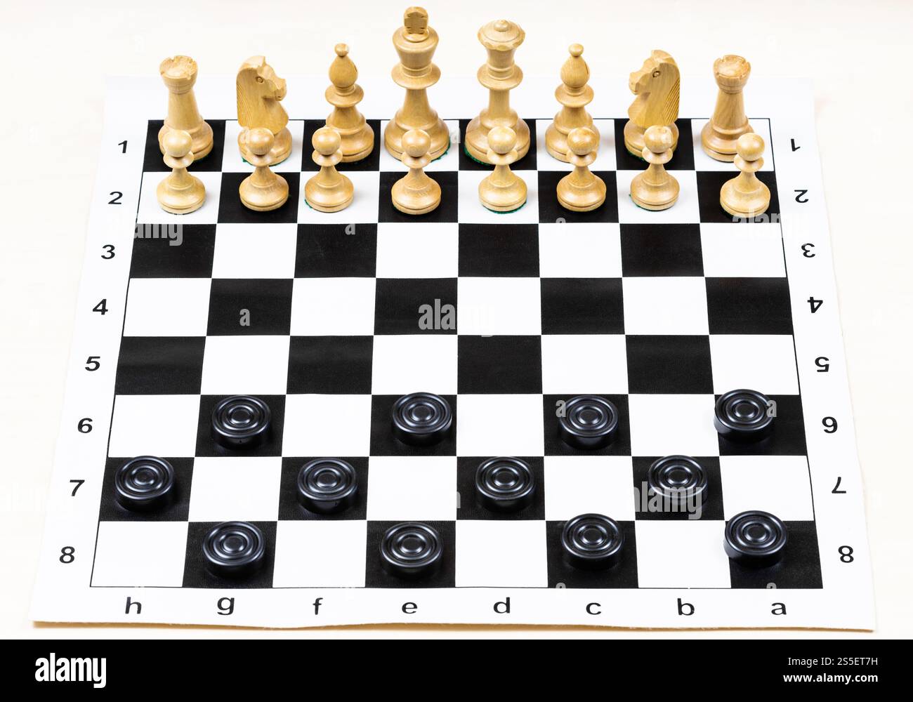 playing by different rules on the same board - black checkers and white chess figures on black ...