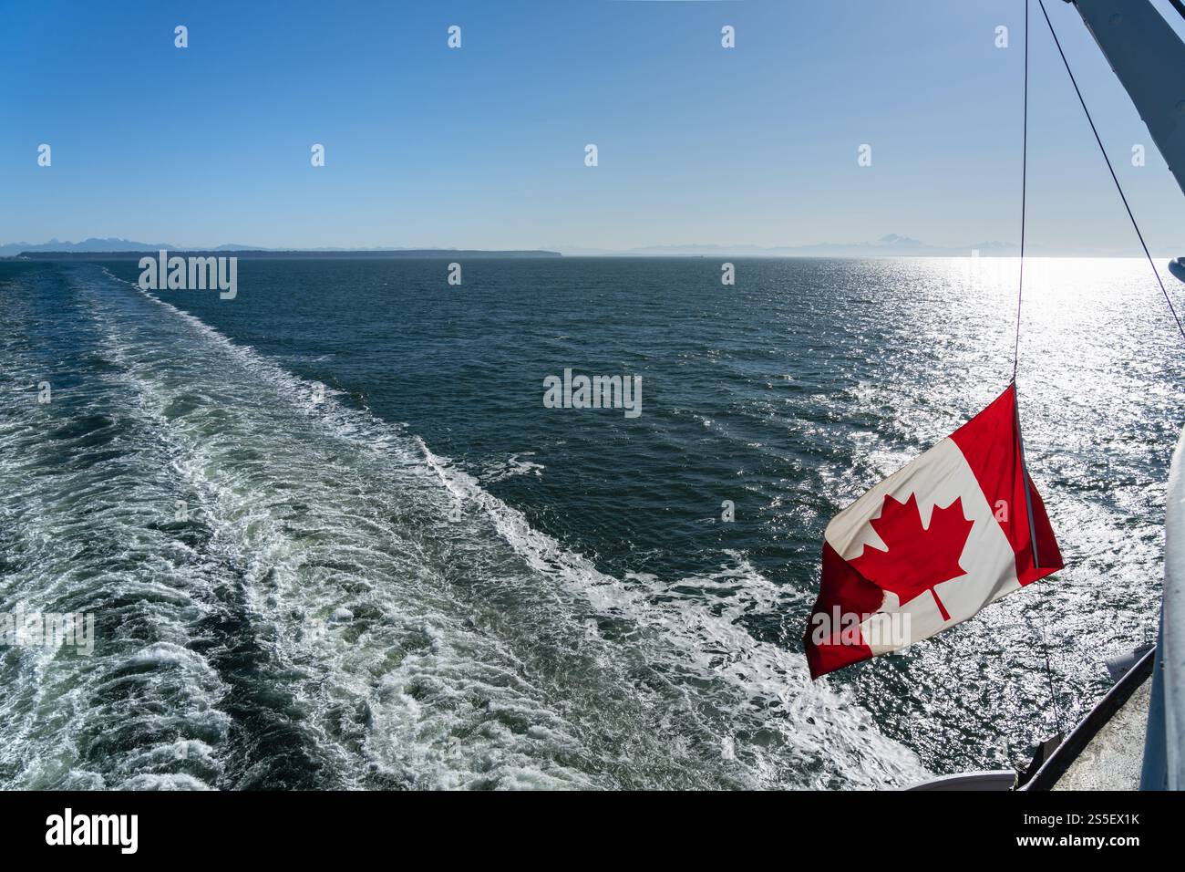 Ferry sailing on the ocean. Canadian flag and waves. Southern Gulf ...