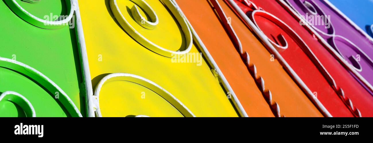 Metal texture of a piece of colored wall with a forged pattern. Rainbow ...